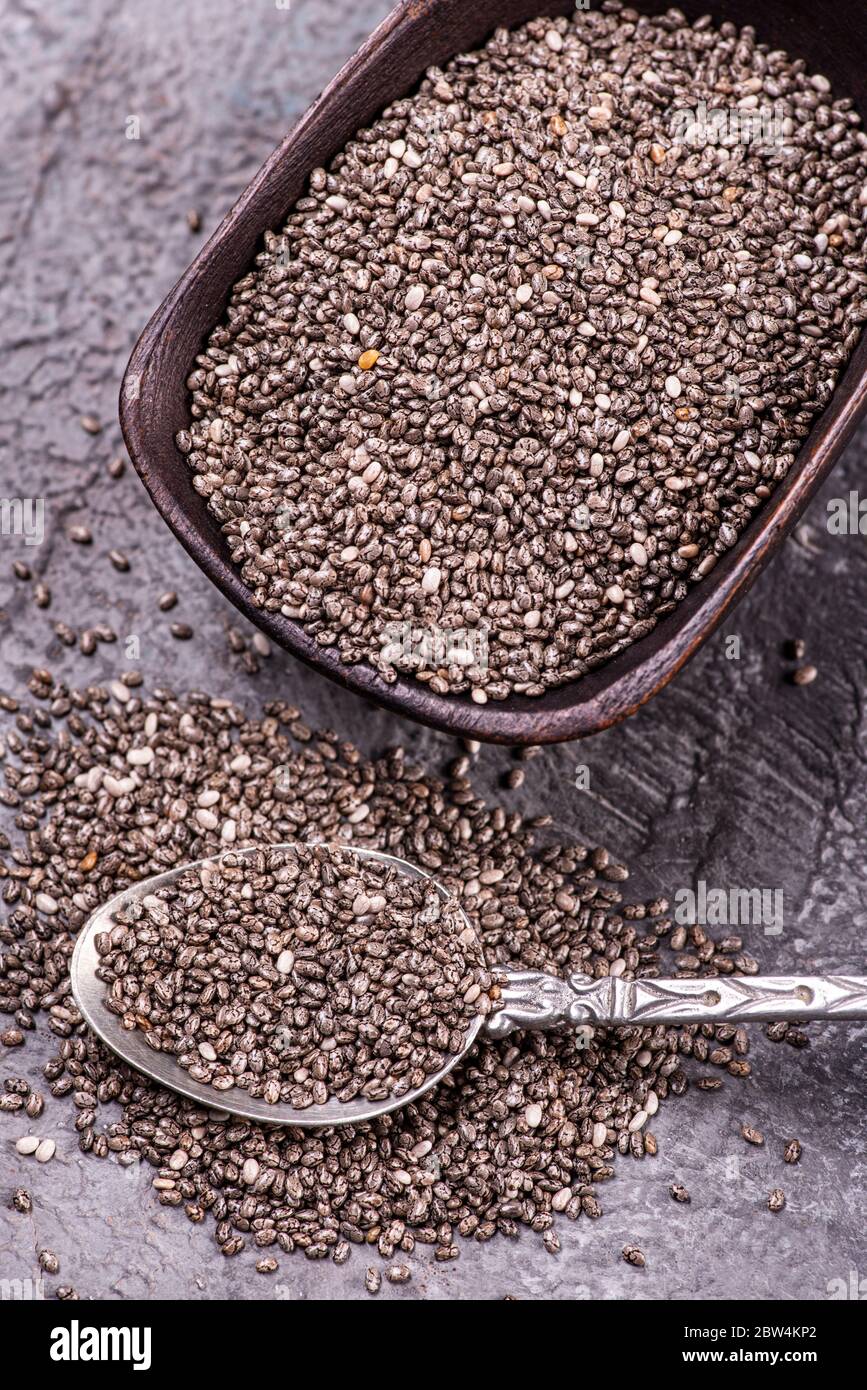 on a gray structure, top view, a pile of chia seeds, with spoon, close ...