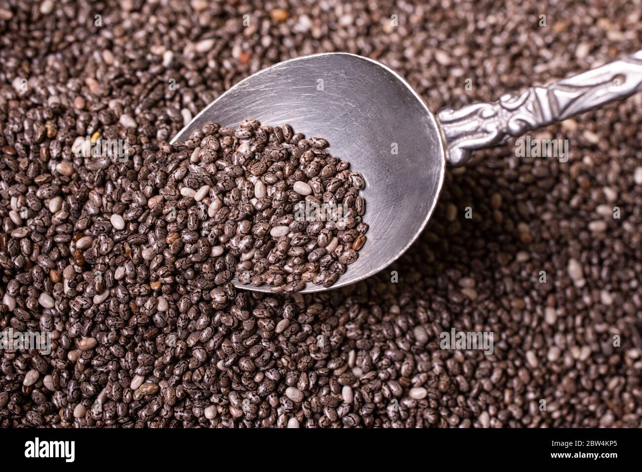on a gray structure, top view, a pile of chia seeds, with spoon, close ...