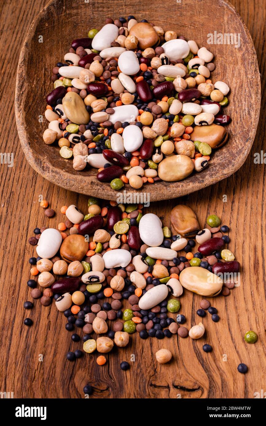 in the foreground, varieties of dried legumes mixed in a large spoon ...