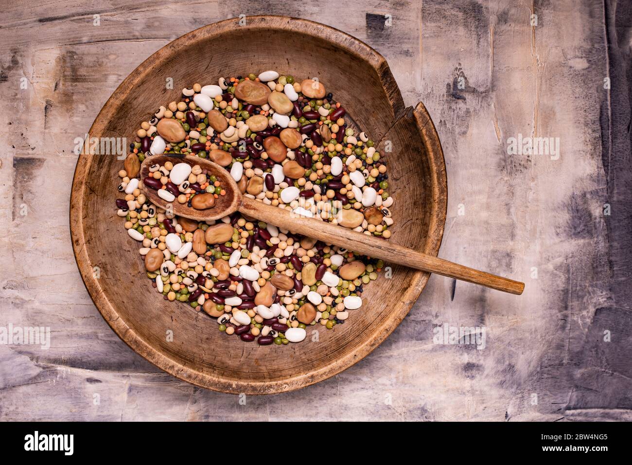 top view, in a rustic wooden plate variety of raw and colorful dry ...