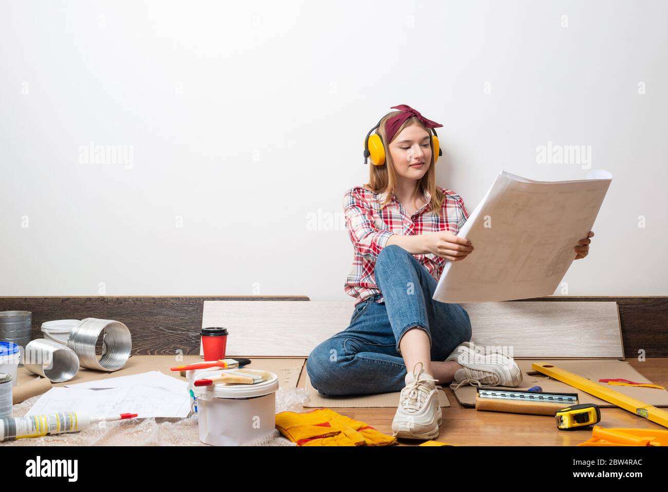 Beautiful girl sitting with paper blueprint Stock Photo - Alamy