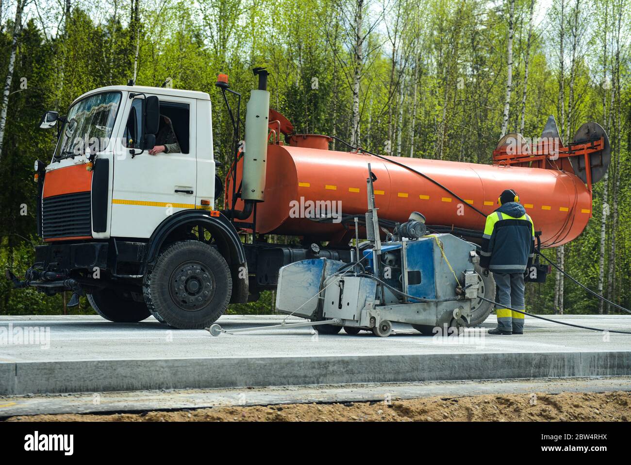 People on road equipment build a concrete road pavement Stock Photo - Alamy