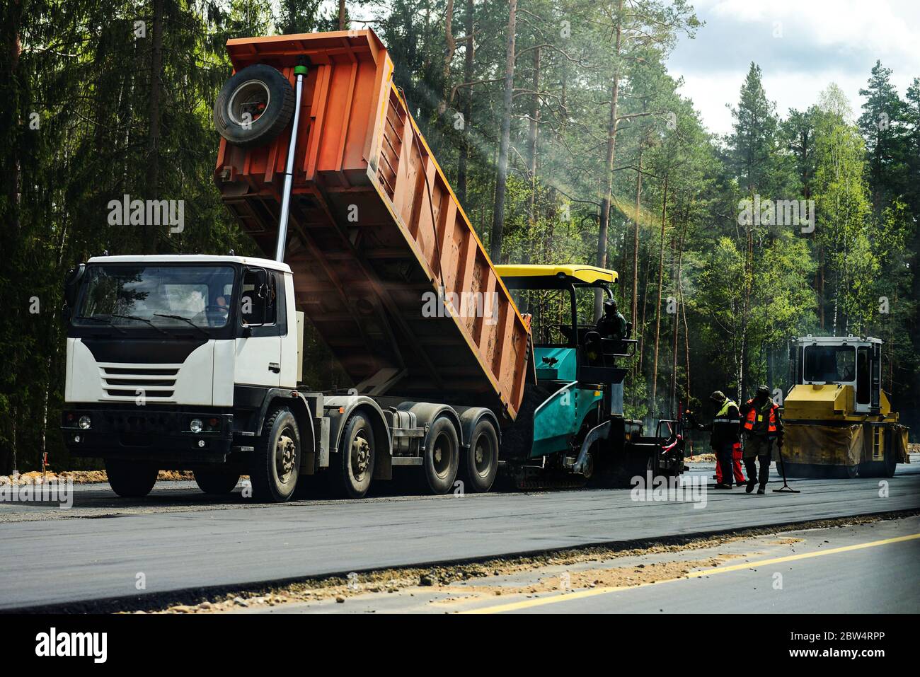 People on road equipment build a concrete road pavement Stock Photo - Alamy