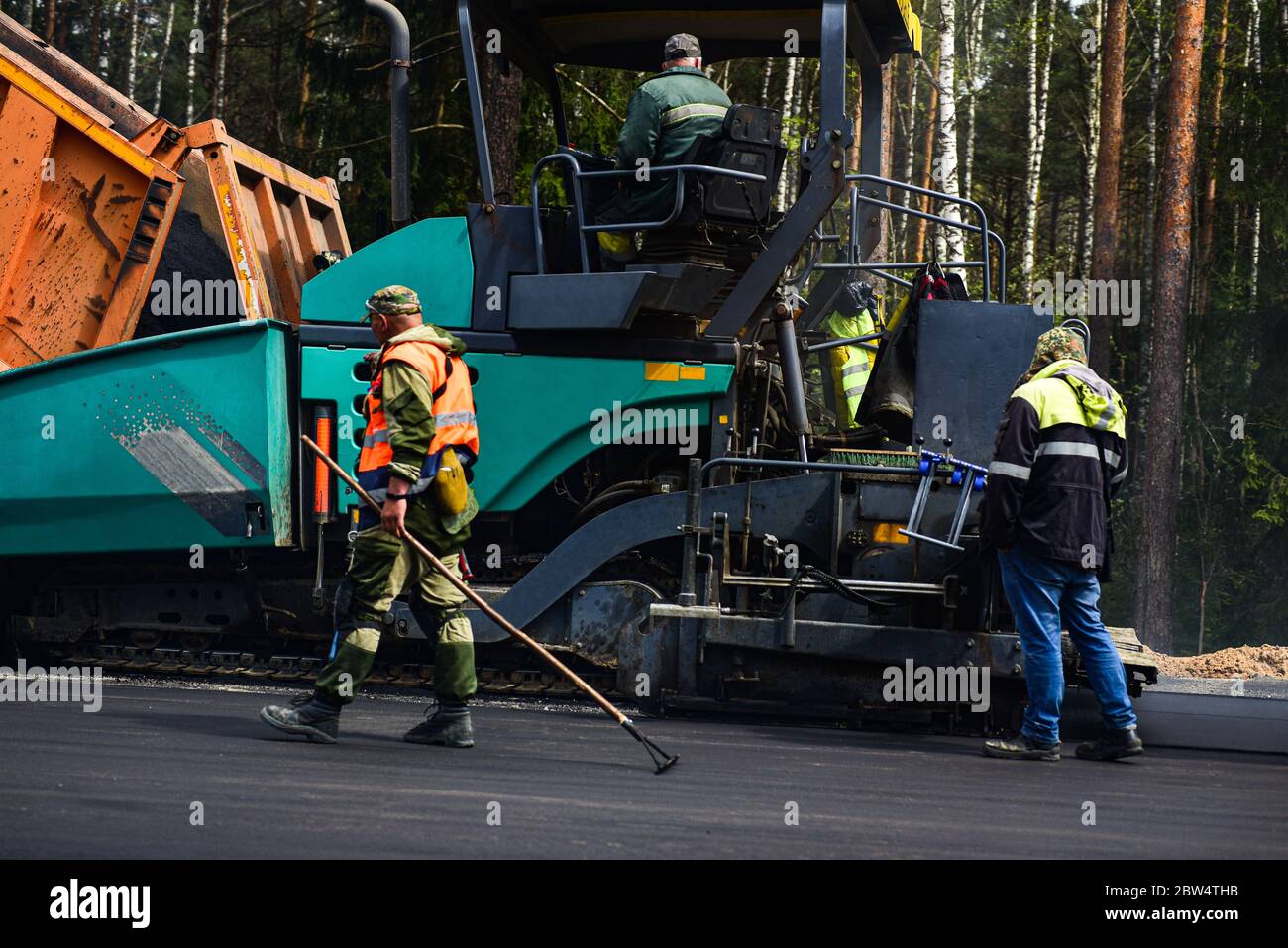 People on road equipment build a concrete road pavement Stock Photo - Alamy