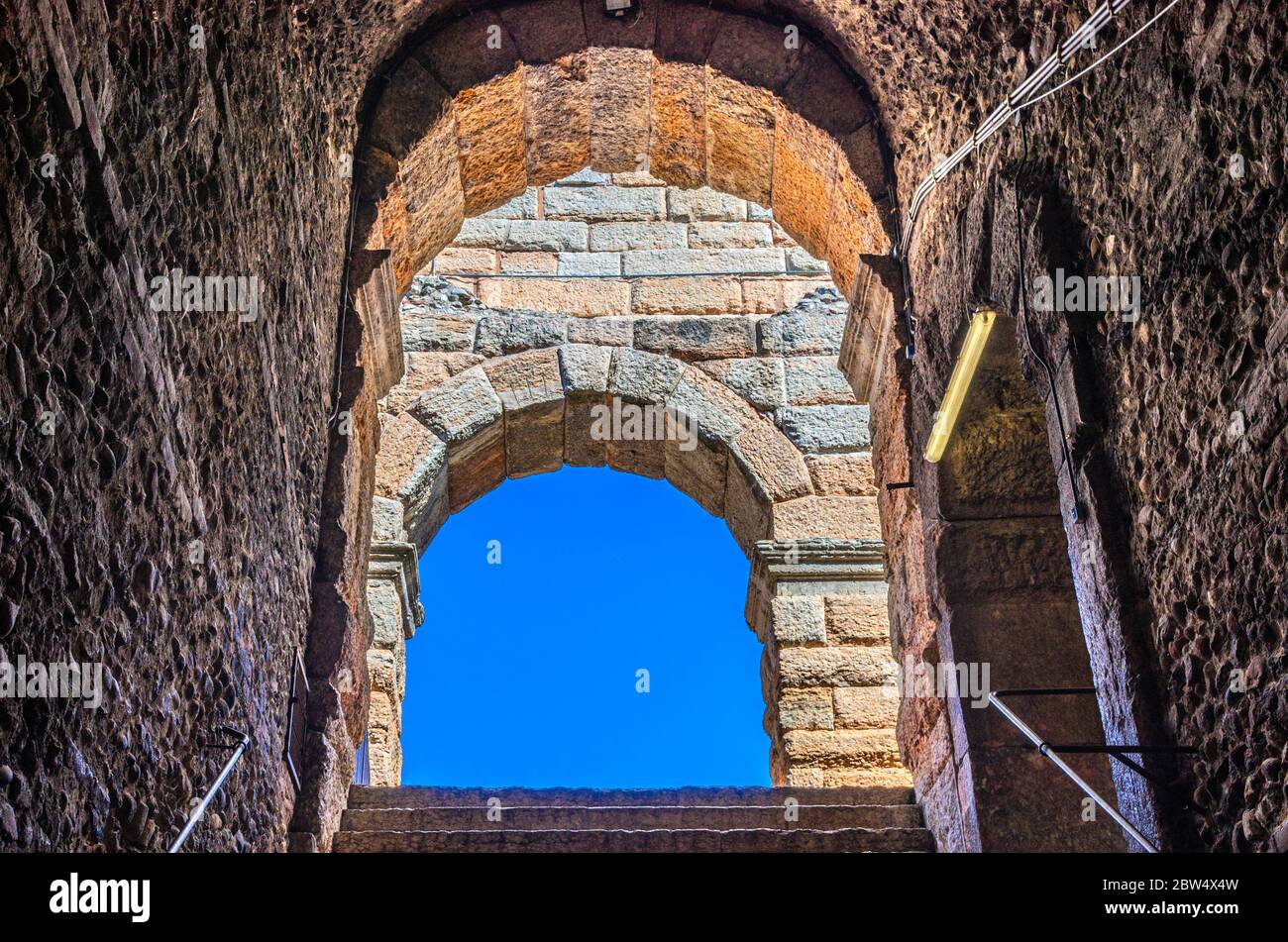 Blue clear sky through limestone brick arch window of The Verona Arena ...