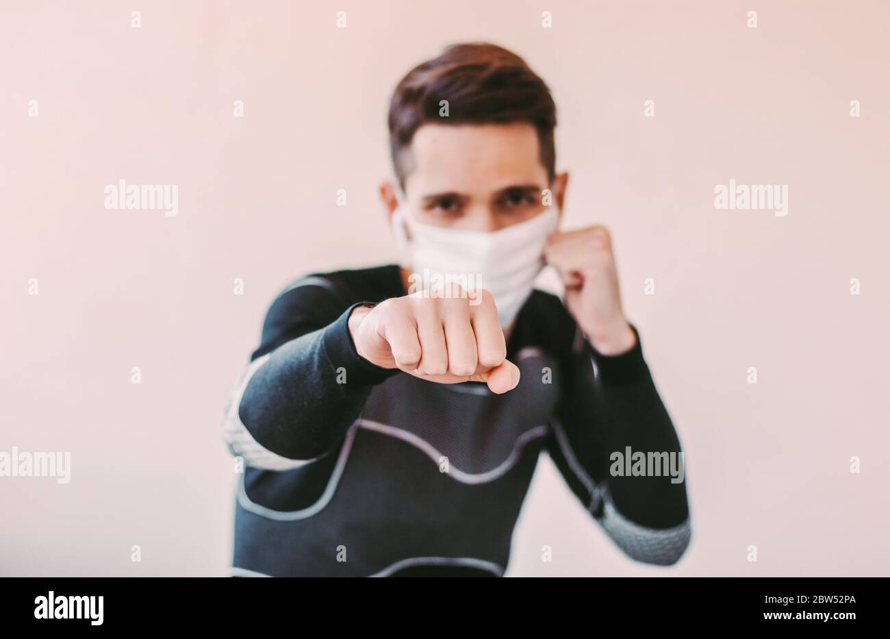 Strong aggressive sports man boxer in protective medical face mask ...