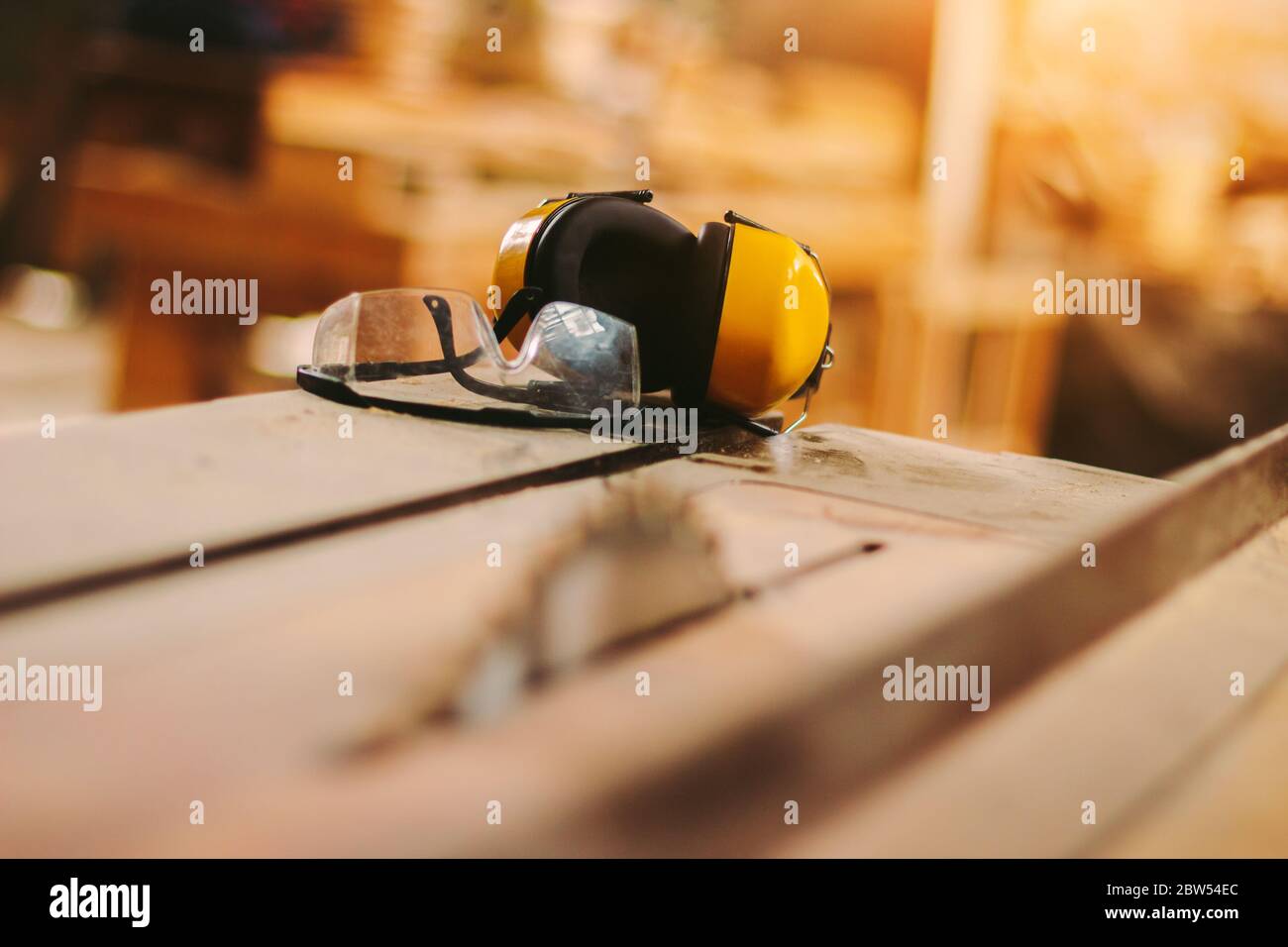 Closeup of protective headphones and glasses on sawing machine table at ...