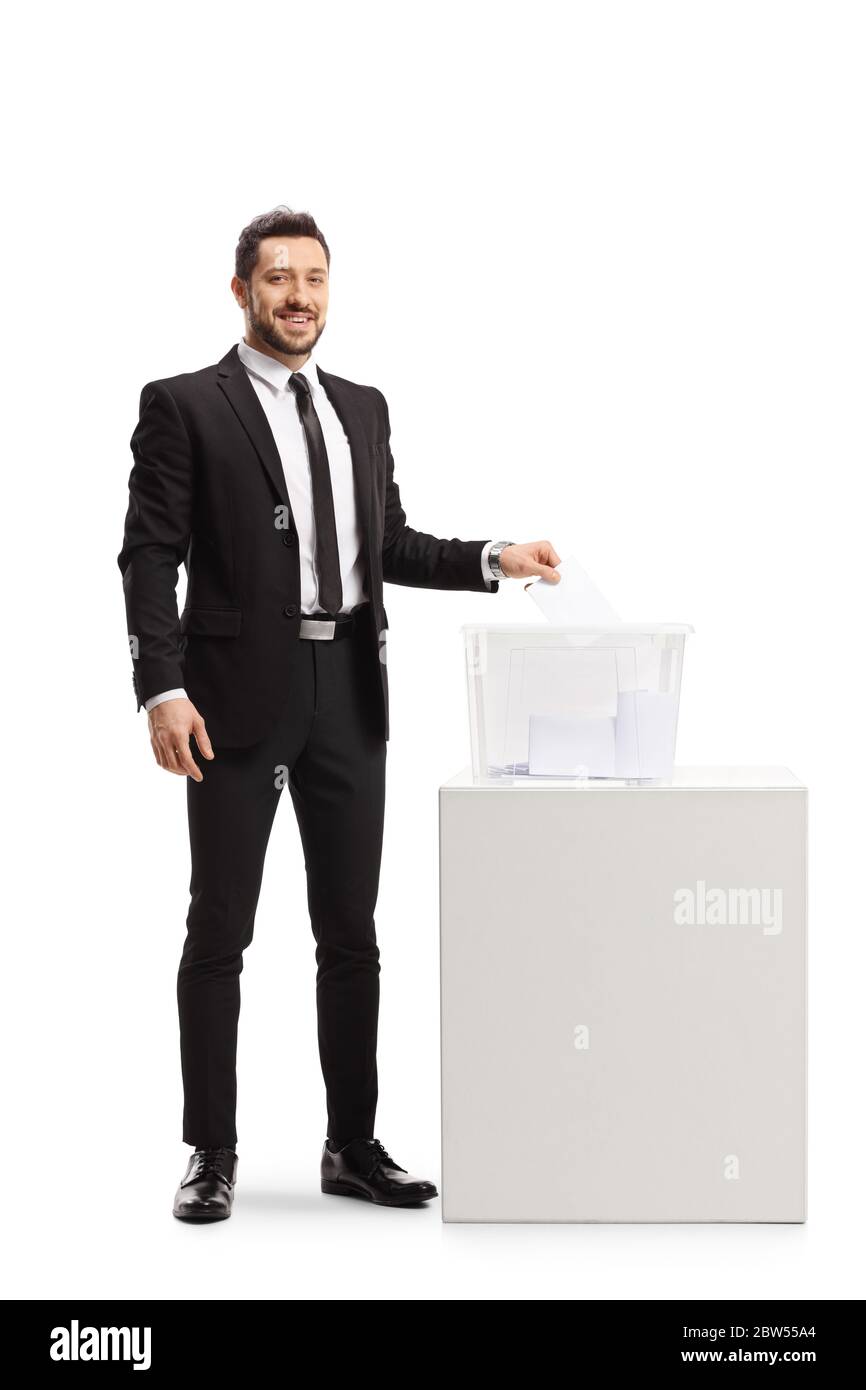 Full length portrait of a man in a suit casting a vote in a ballot box ...