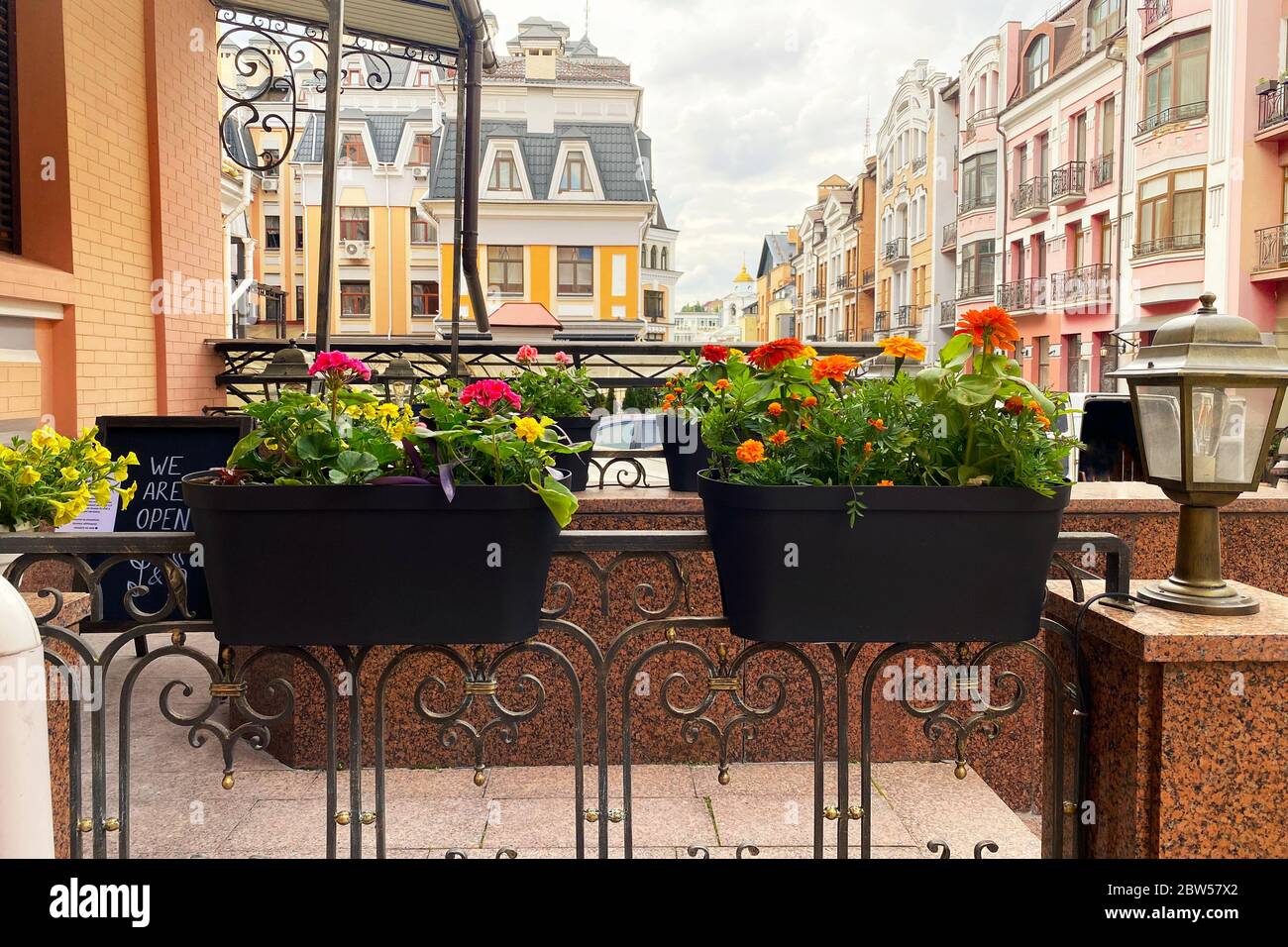 Blooming flowers in pots on street in residential complex. Pots with ...