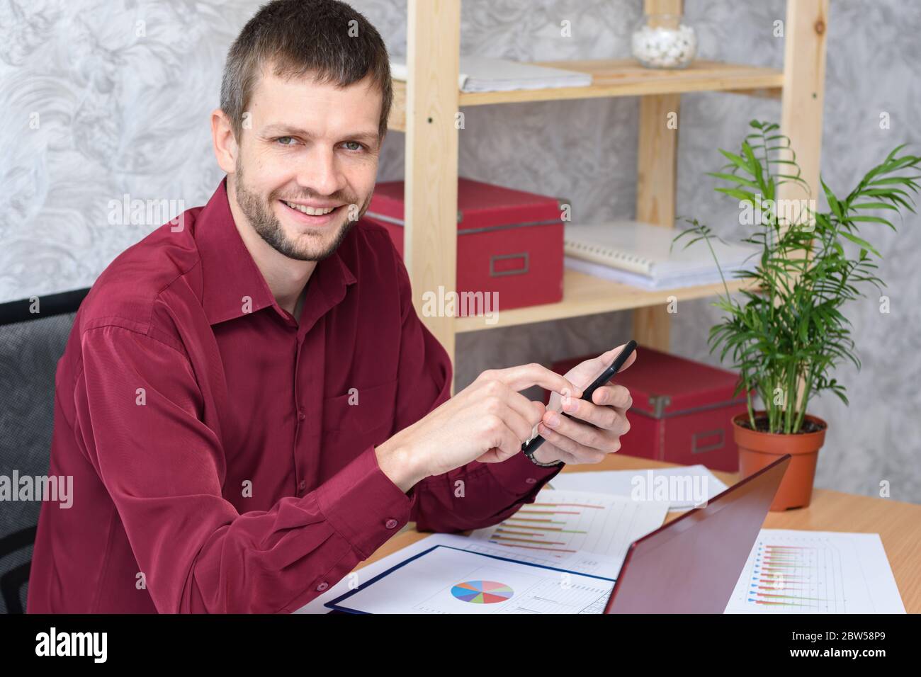 Smiling office worker corresponds on his smartphone Stock Photo - Alamy