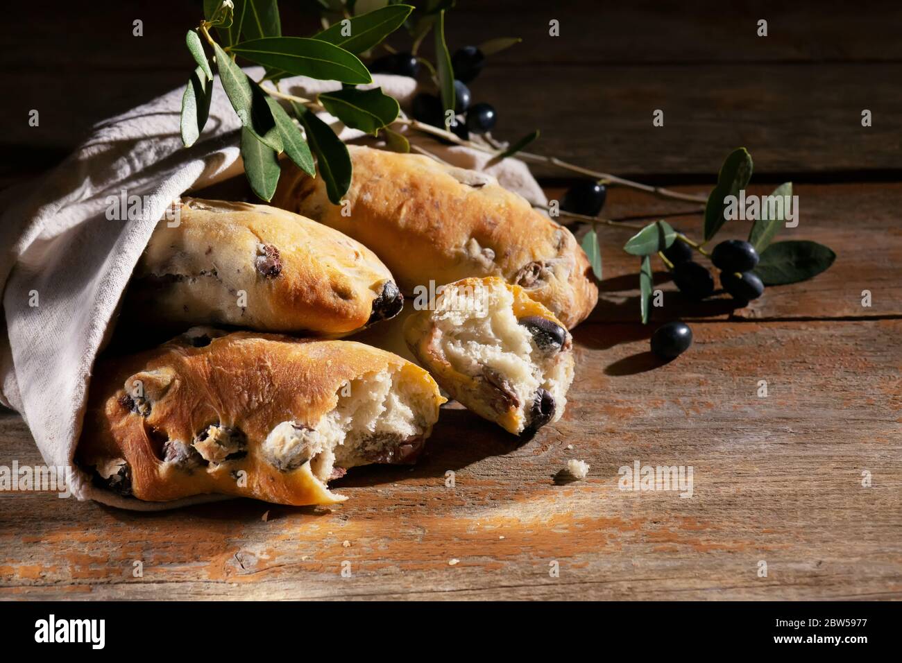 Traditional italian puccia breads with black olives in a cotton bag ...