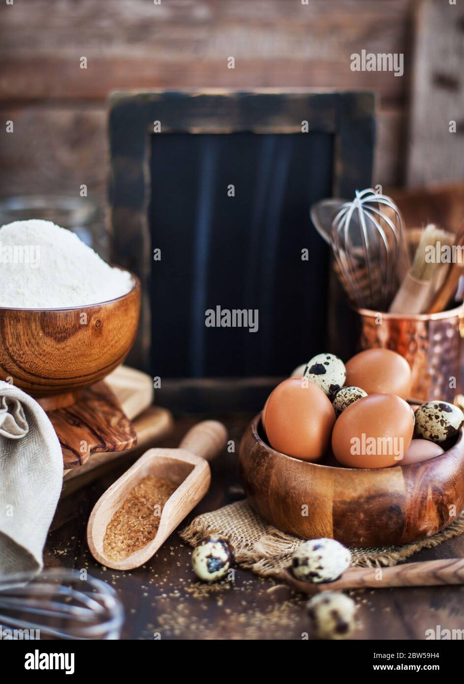 Baking ingredients and blackboard on background, wooden rustic style ...