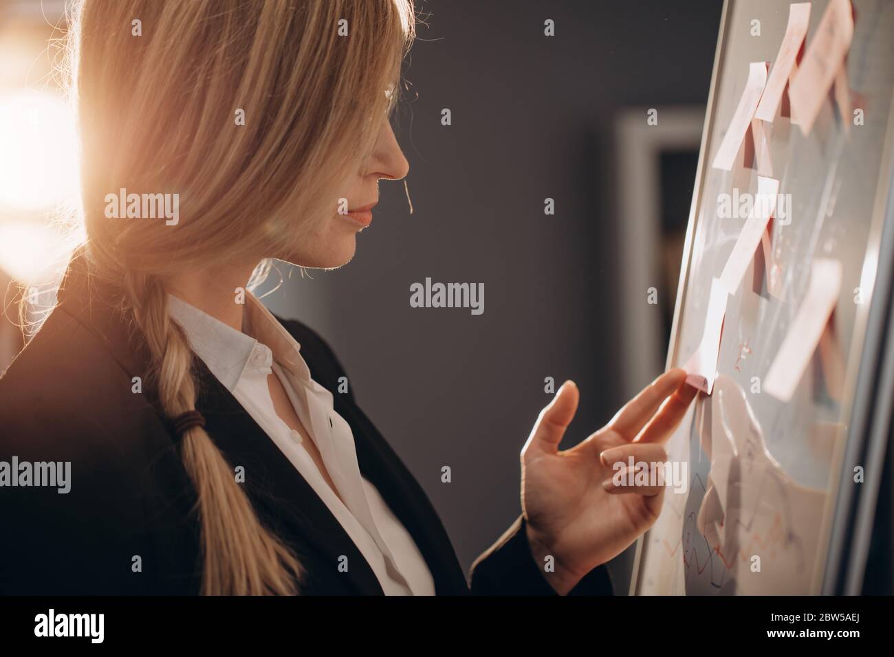 Confident business putting on stickers on clipboard Stock Photo - Alamy