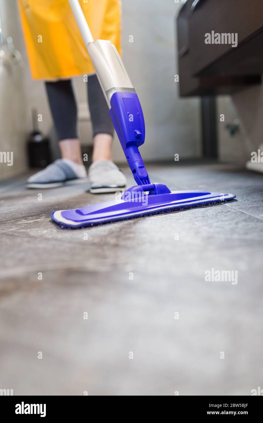 Maid doing chores at home by holding mopping stick. Coronavirus ...