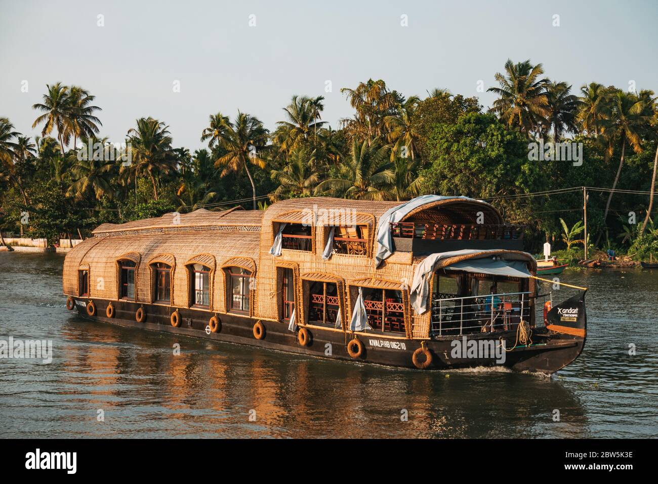 A houseboat cruises down a canal in the Kerala backwaters in the ...