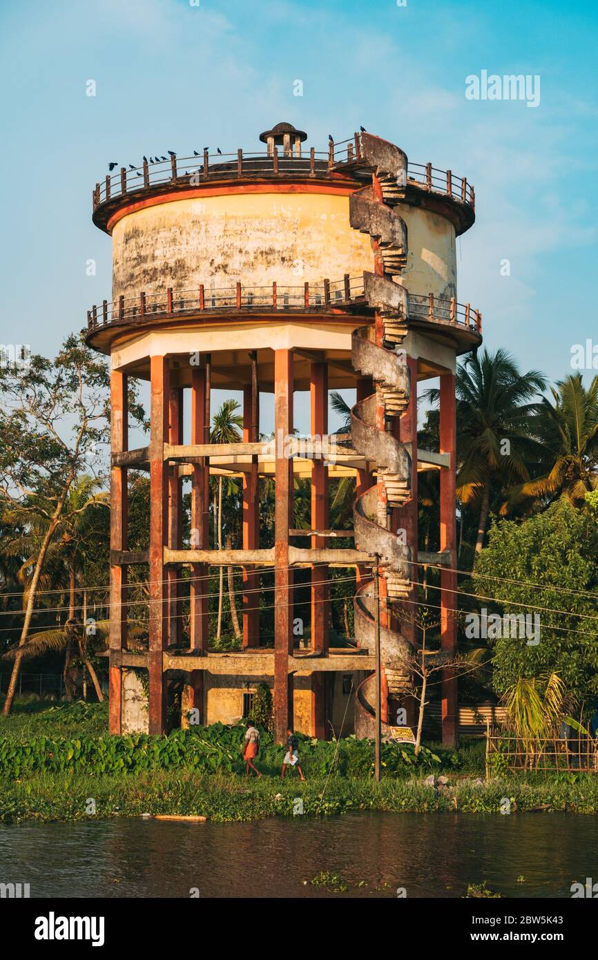 A concrete water tower seen along the banks of the backwaters in Kerala ...