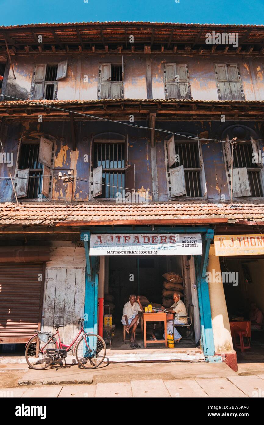 Two men sit at a table in an old trading merchant colonial building in ...