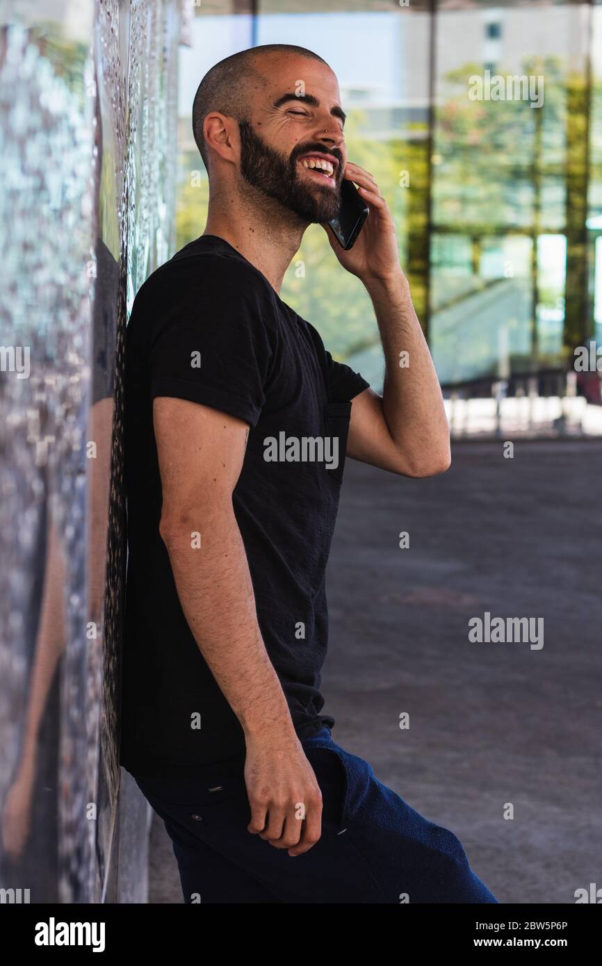 Smiling man in wattled hat smiling while making a call Stock Photo - Alamy