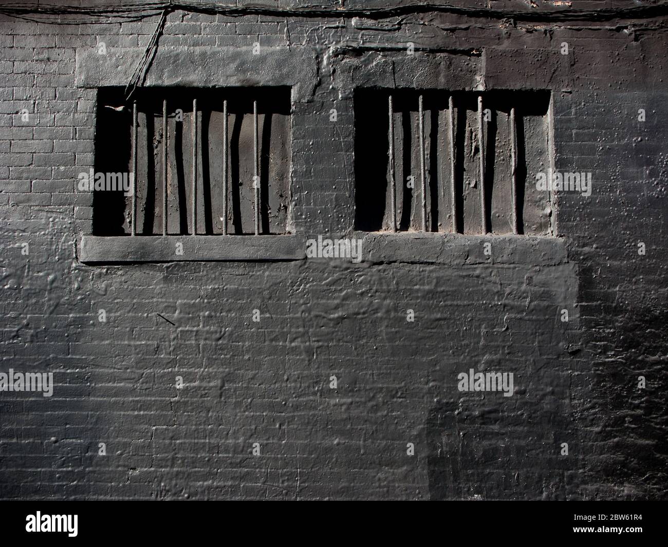 Black Brick Wall with Barred Windows Stock Photo - Alamy