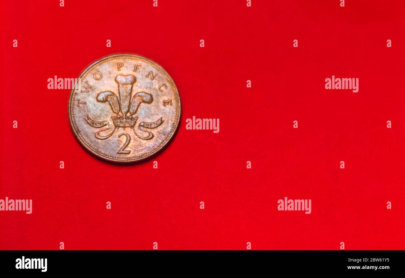 British coin 2 pence (2001) isolated on red background with blurry and ...