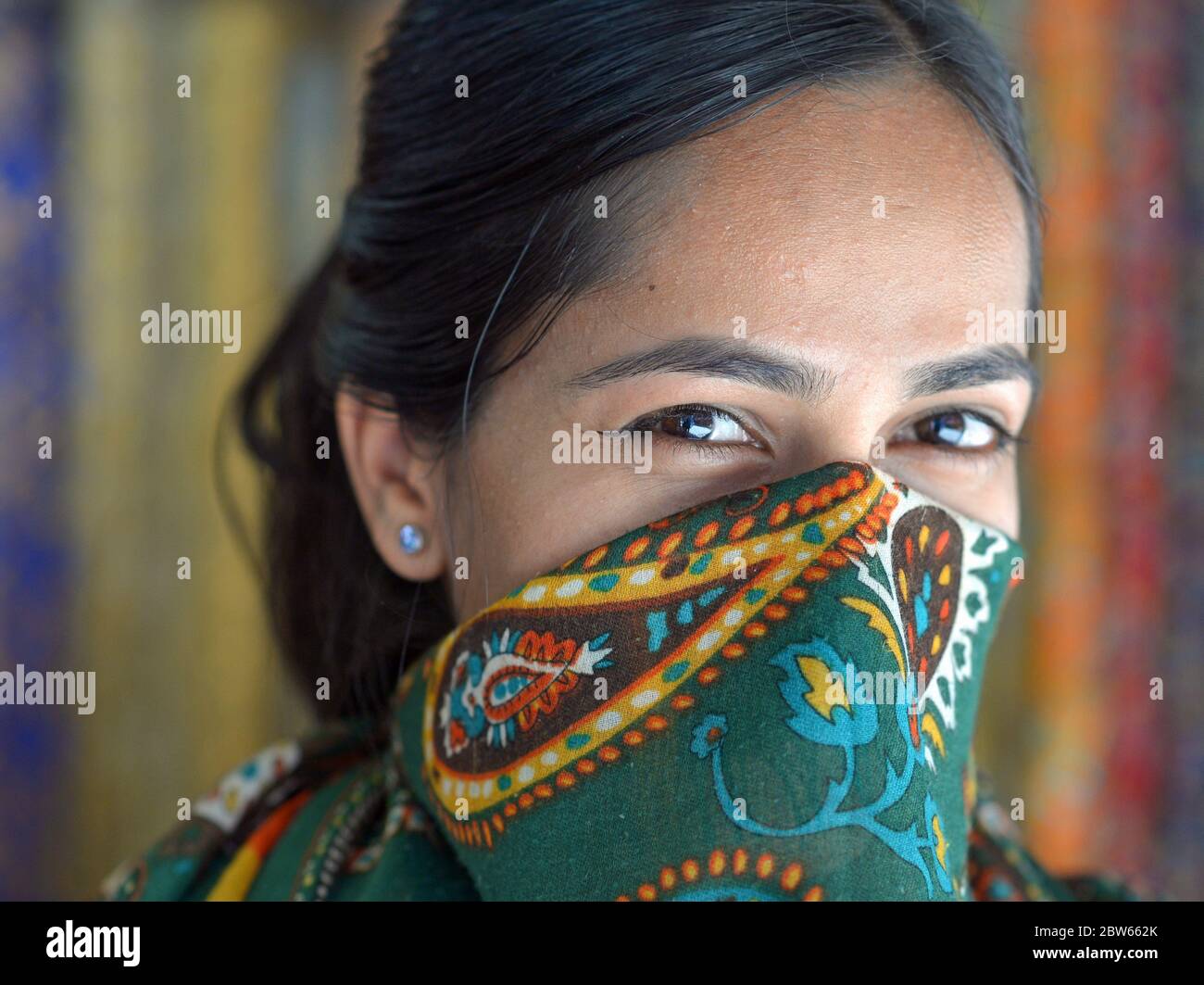 Young Nepali woman with beautiful eyes covers her nose and mouth with a ...