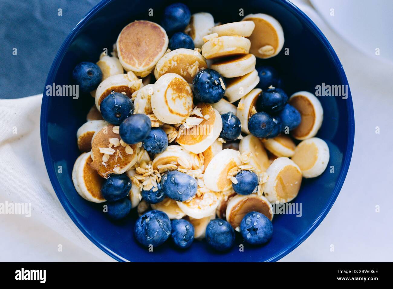 Close- up of Mini Pancake cereal, mini pancakes in a dark blue bowl ...