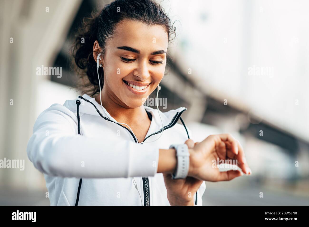 Smiling woman checking her physical activity on smartwatch. Young ...