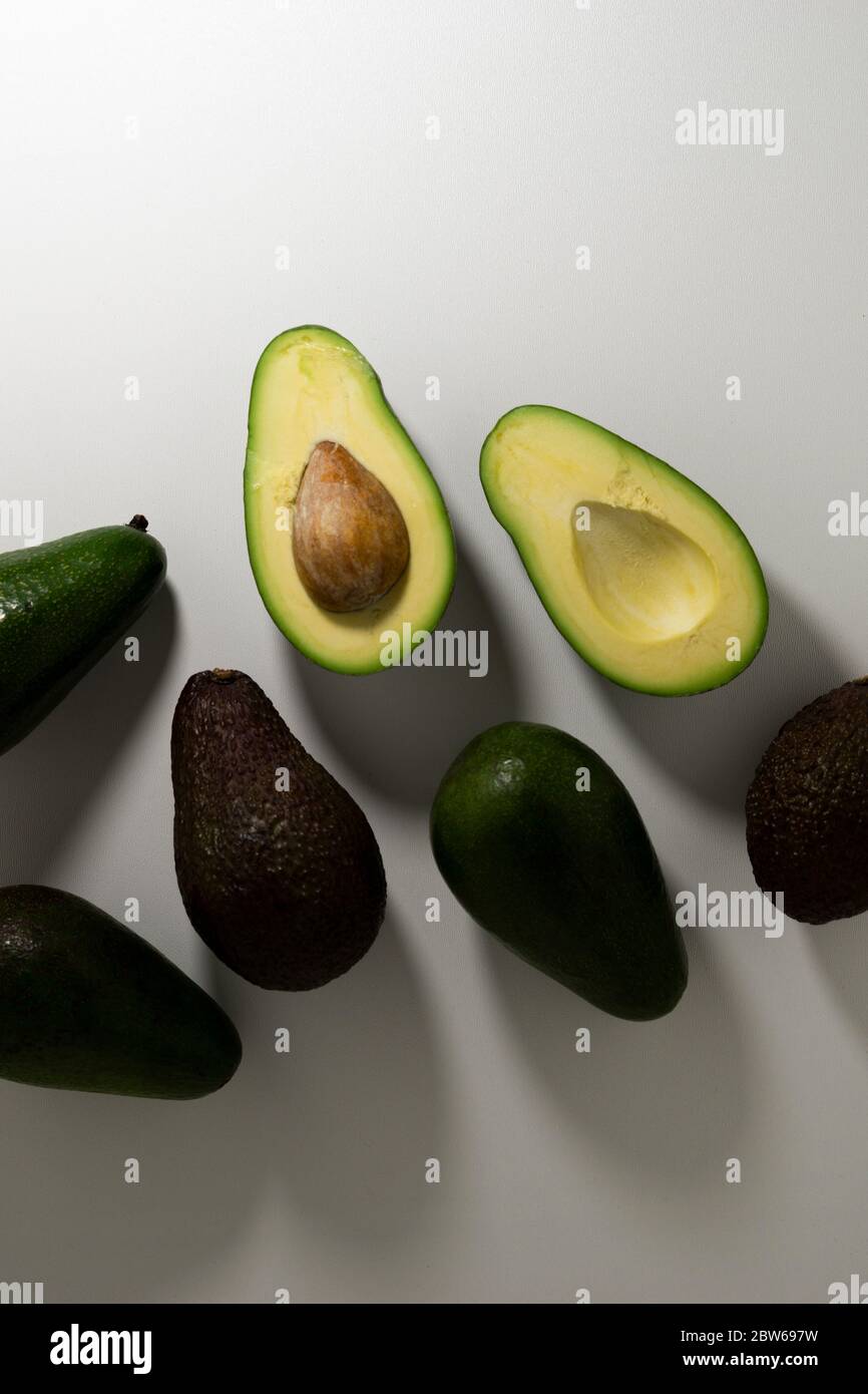 Ripe avocado fruits whole and sliced on a white background. Top View ...