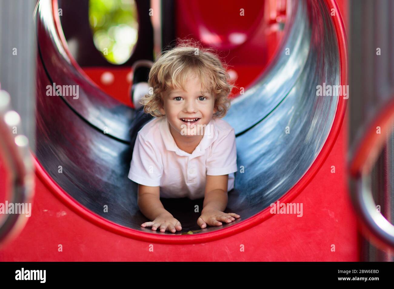 Child playing on outdoor playground. Kids play on school or ...