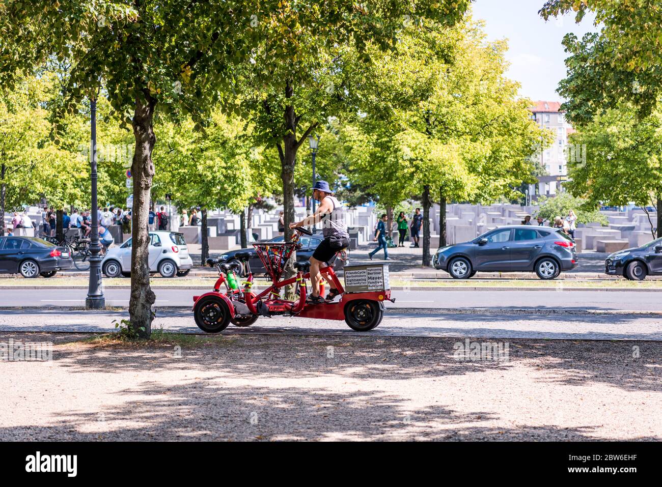 A man riding a bicycle with background of the Memorial to the Murdered ...