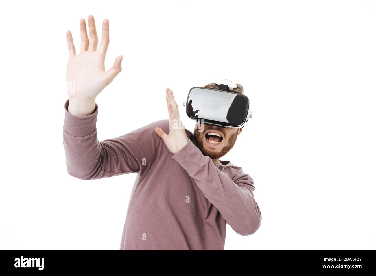 Portrait of young scared boy wearing visual reality glasses on white ...