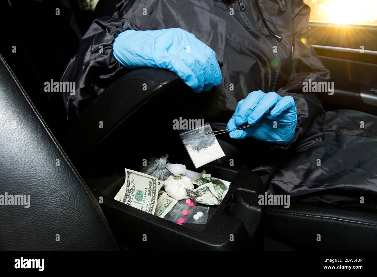 gloved policeman pulls cocaine from the armrest with tweezers Stock ...