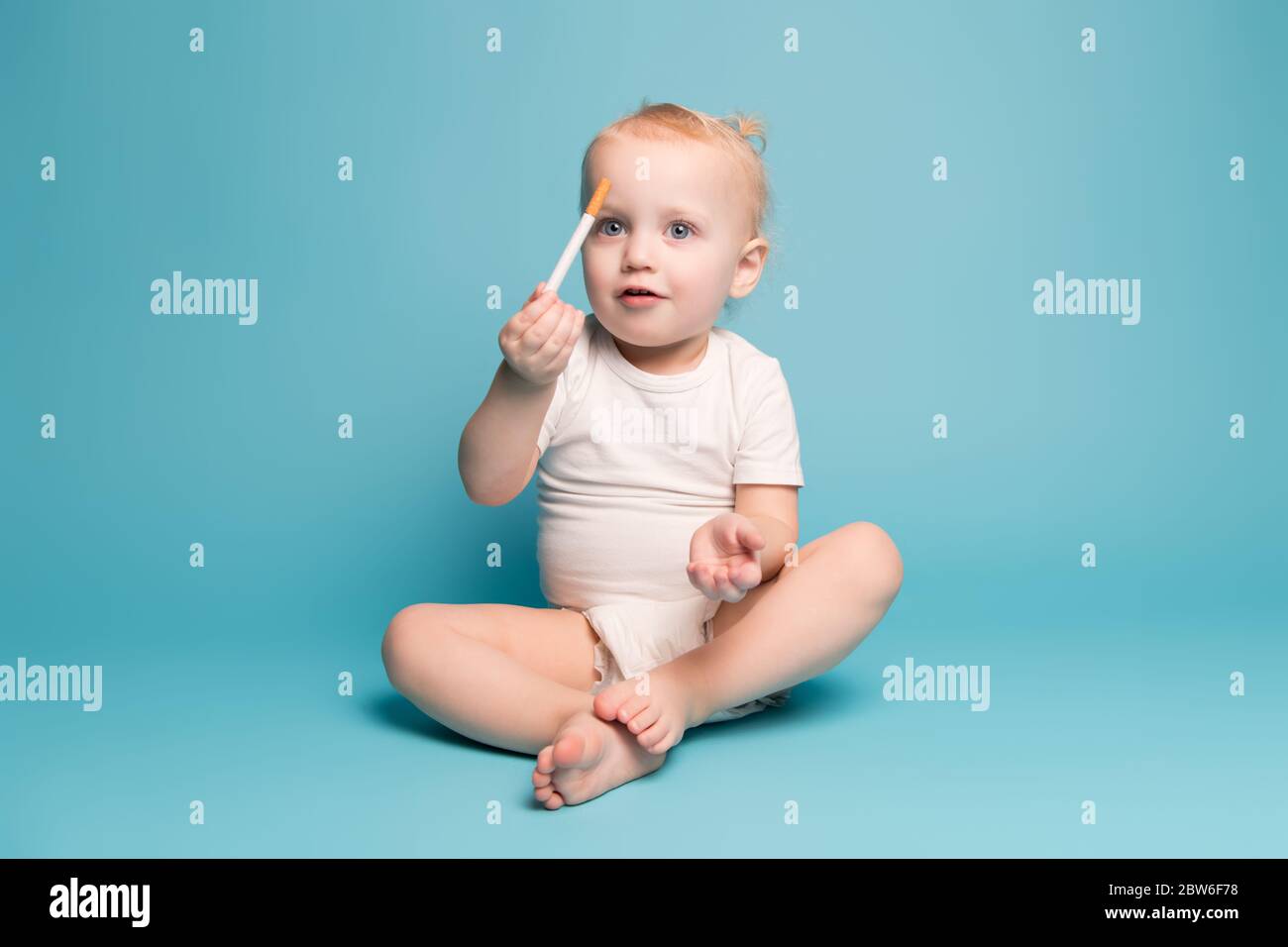 baby girl shows the viewer a cigarette in her hand Stock Photo - Alamy