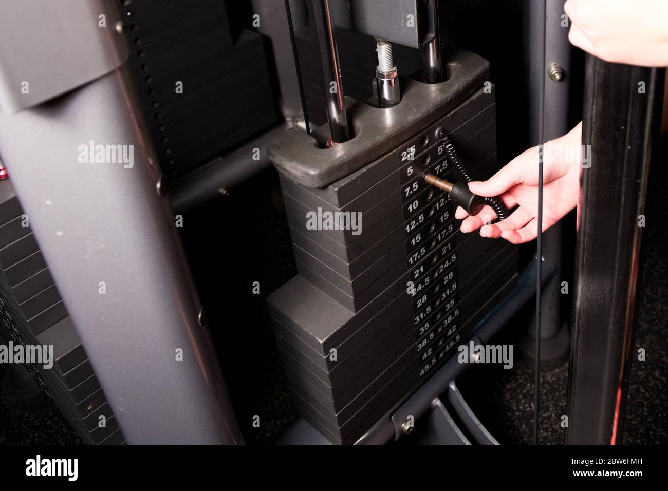 the girl increases the load in the gym, adding weight Stock Photo - Alamy