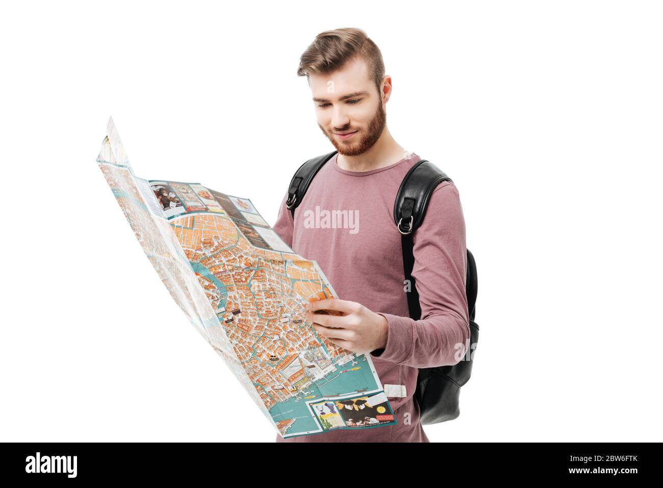 Portrait of young smiling man happily looking on map while holding it ...