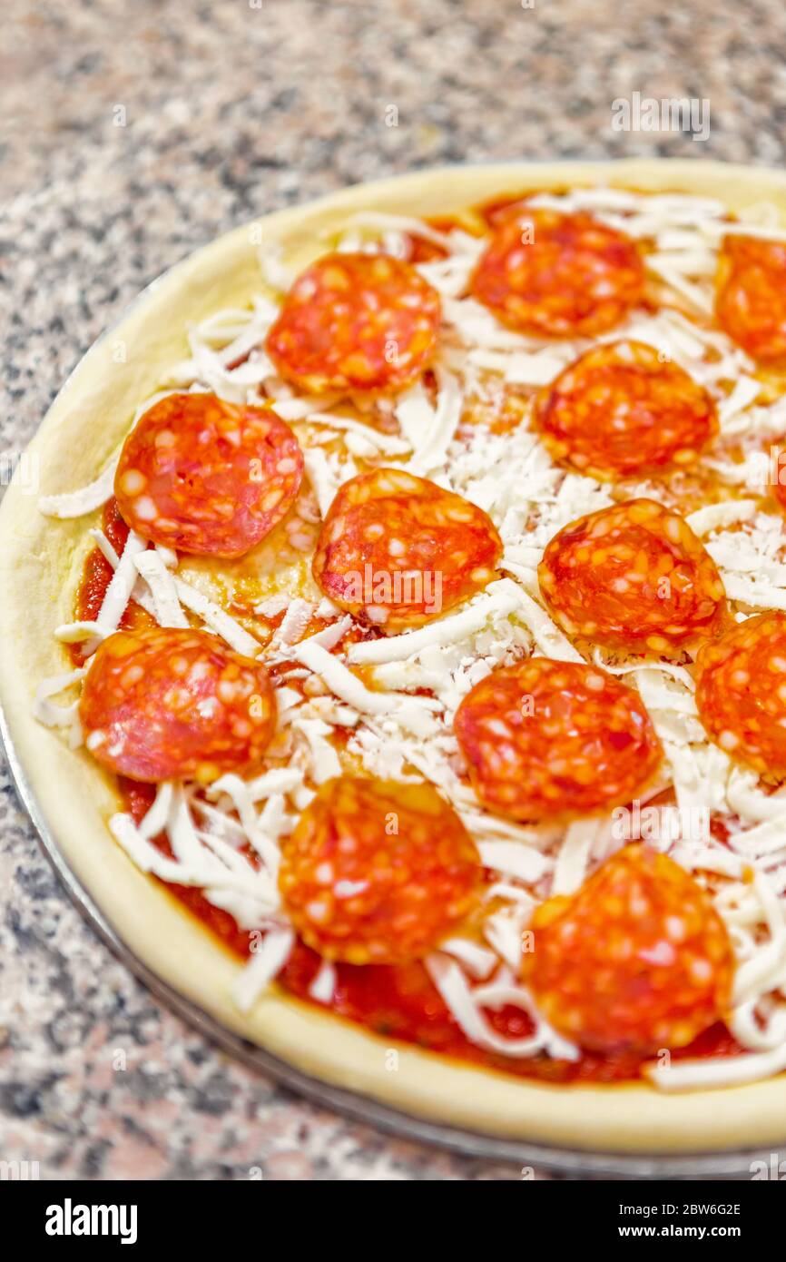 Raw pepperoni pizza with mozarella cheese ready for baking Stock Photo ...