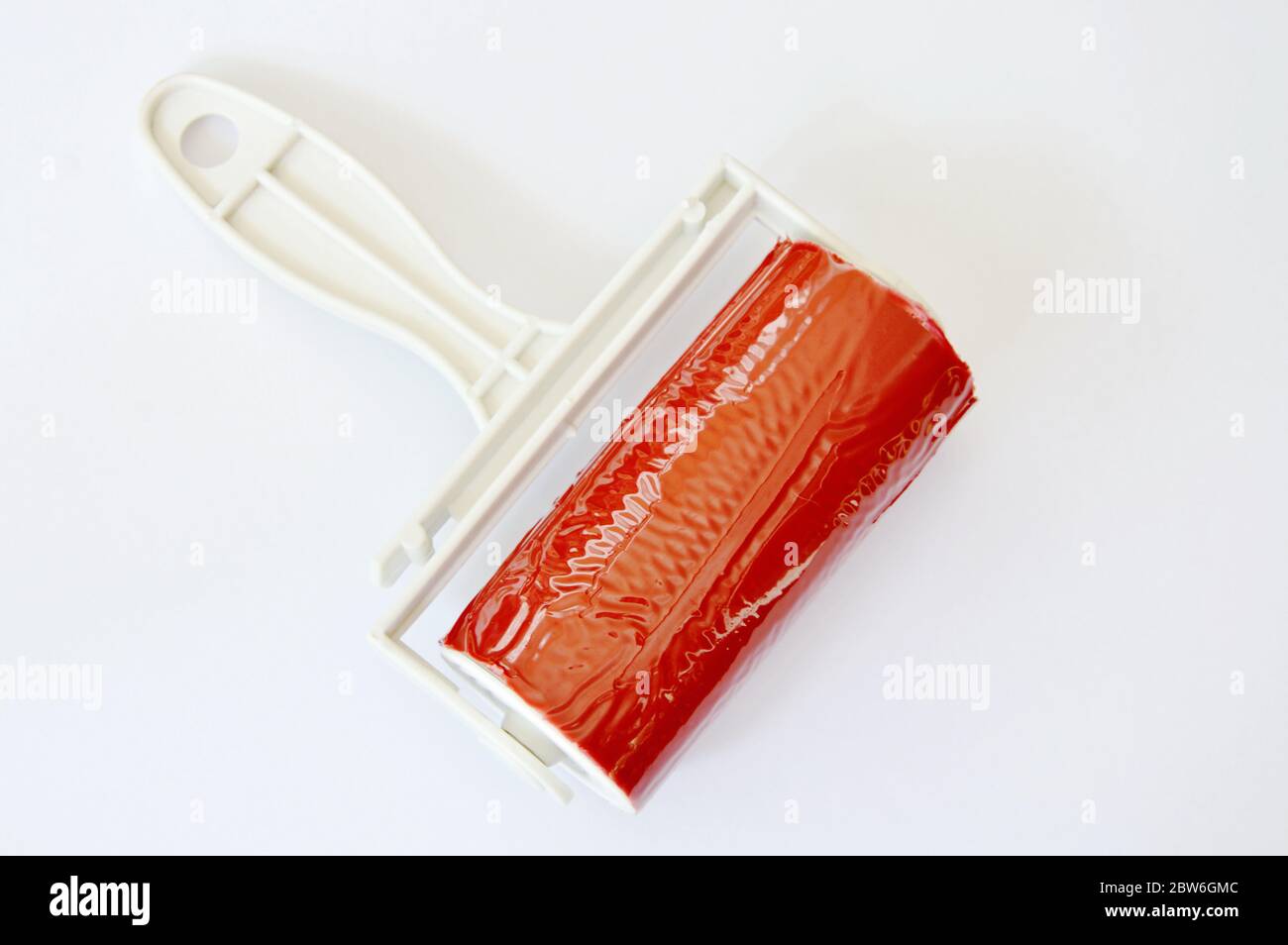 red sticky dust roller on white background Stock Photo - Alamy