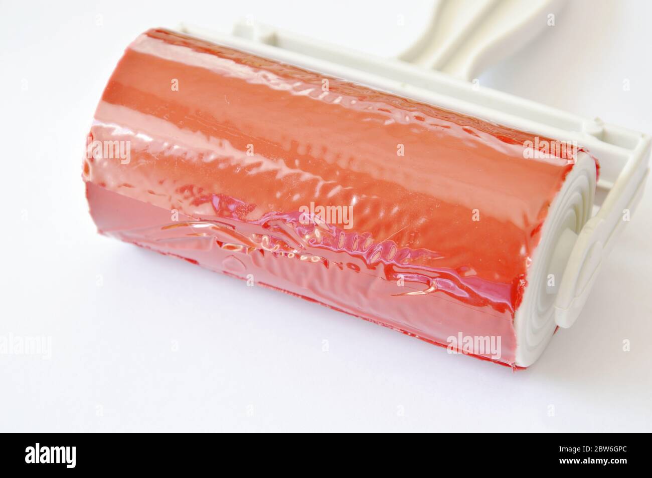 red sticky dust roller on white background Stock Photo - Alamy