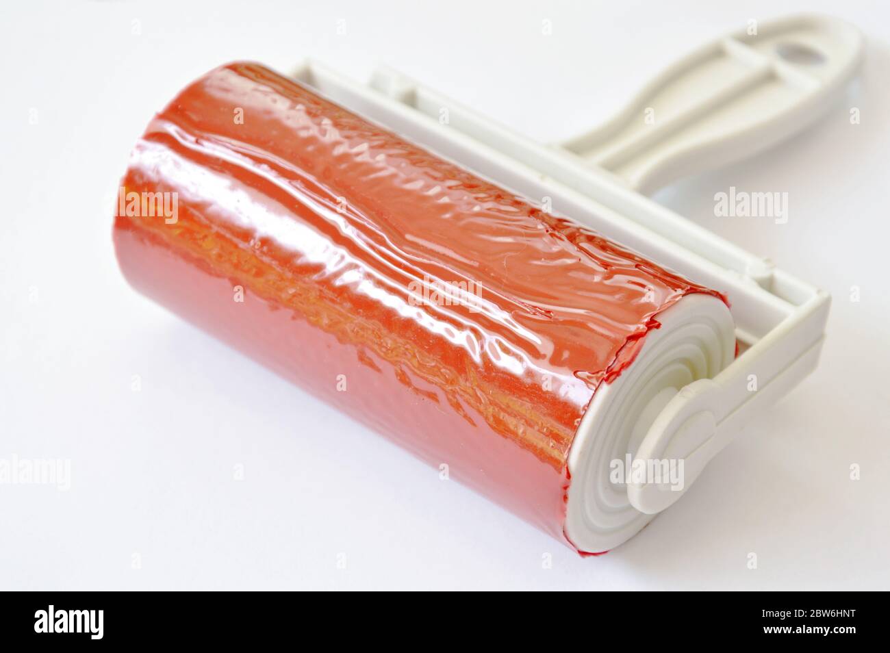 red sticky dust roller on white background Stock Photo - Alamy