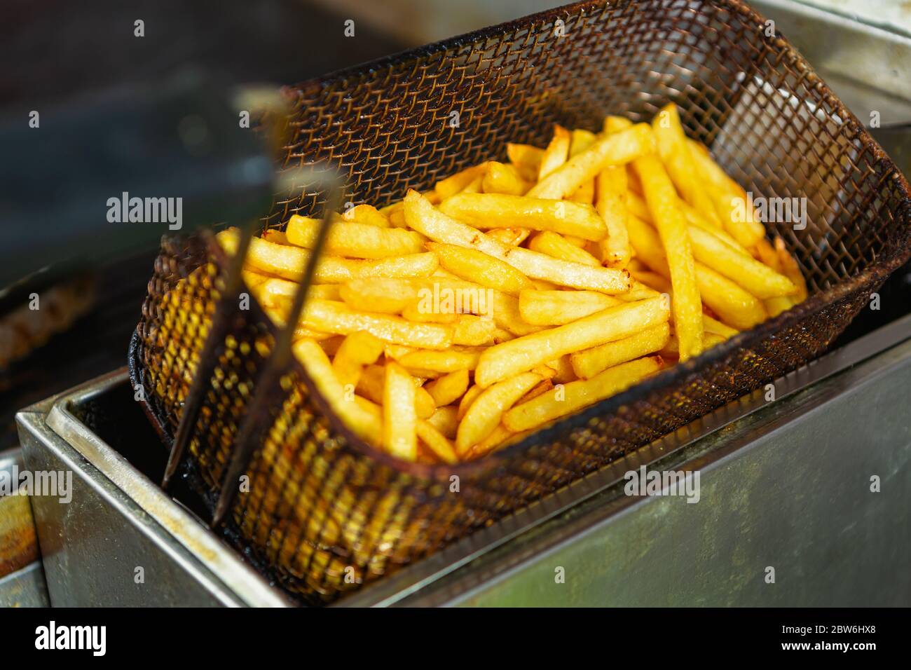 Deep fried French fries in fast food restaurant kitchen.Delicious snack ...