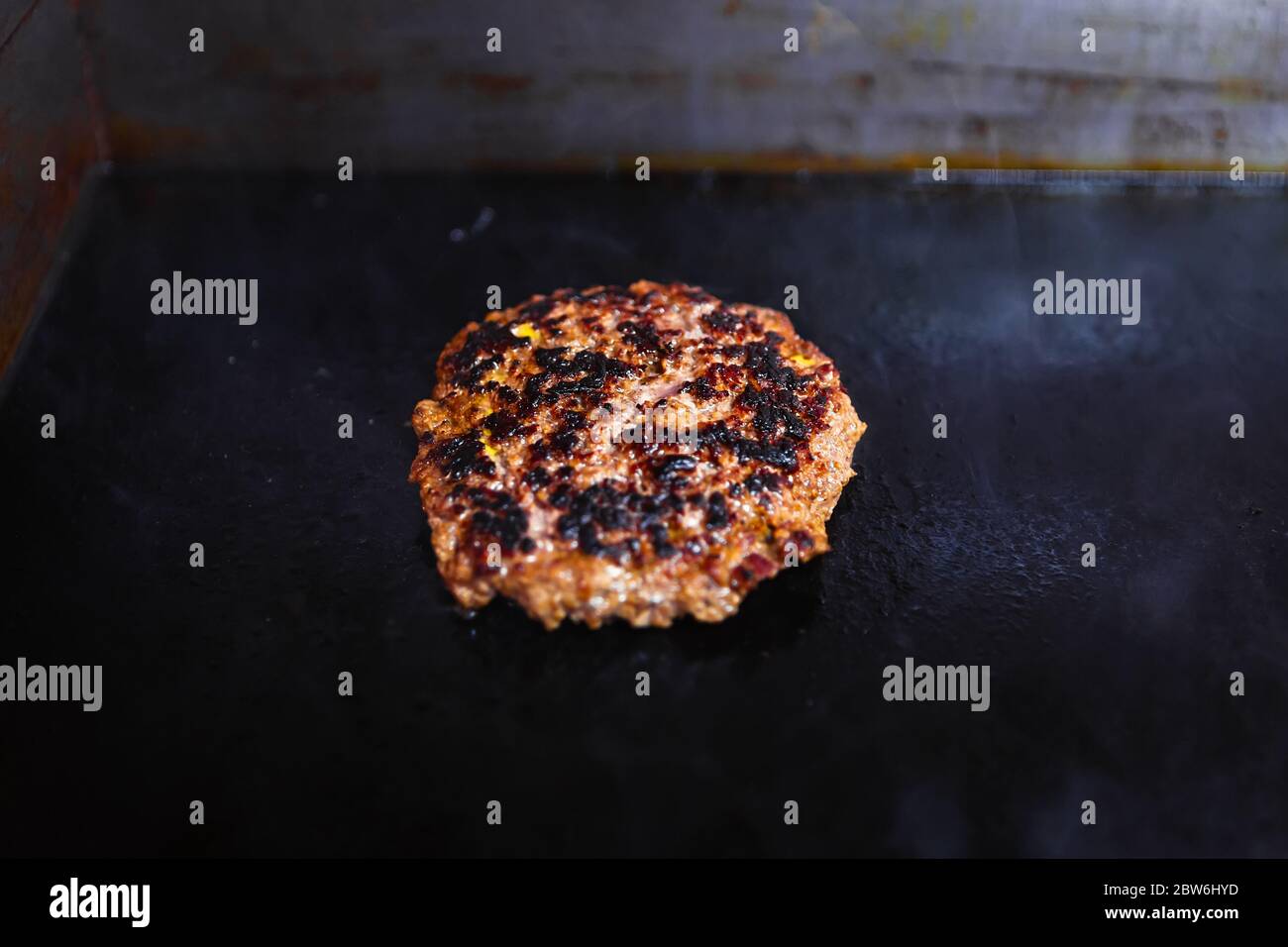 Beef meat cutlet frying on hot pan in fast food restaurant kitchen ...