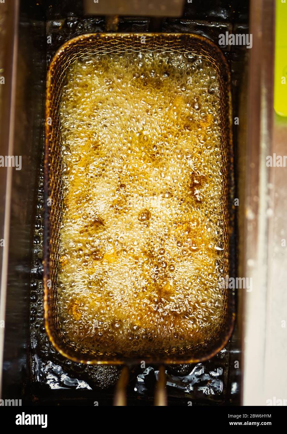 Cooking French fries in hot oil in fast food restaurant kitchen Stock ...