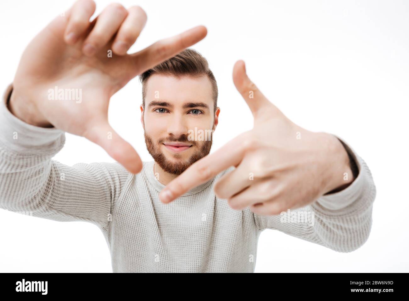 Young man making finger frame as a director of photography and smilibg ...