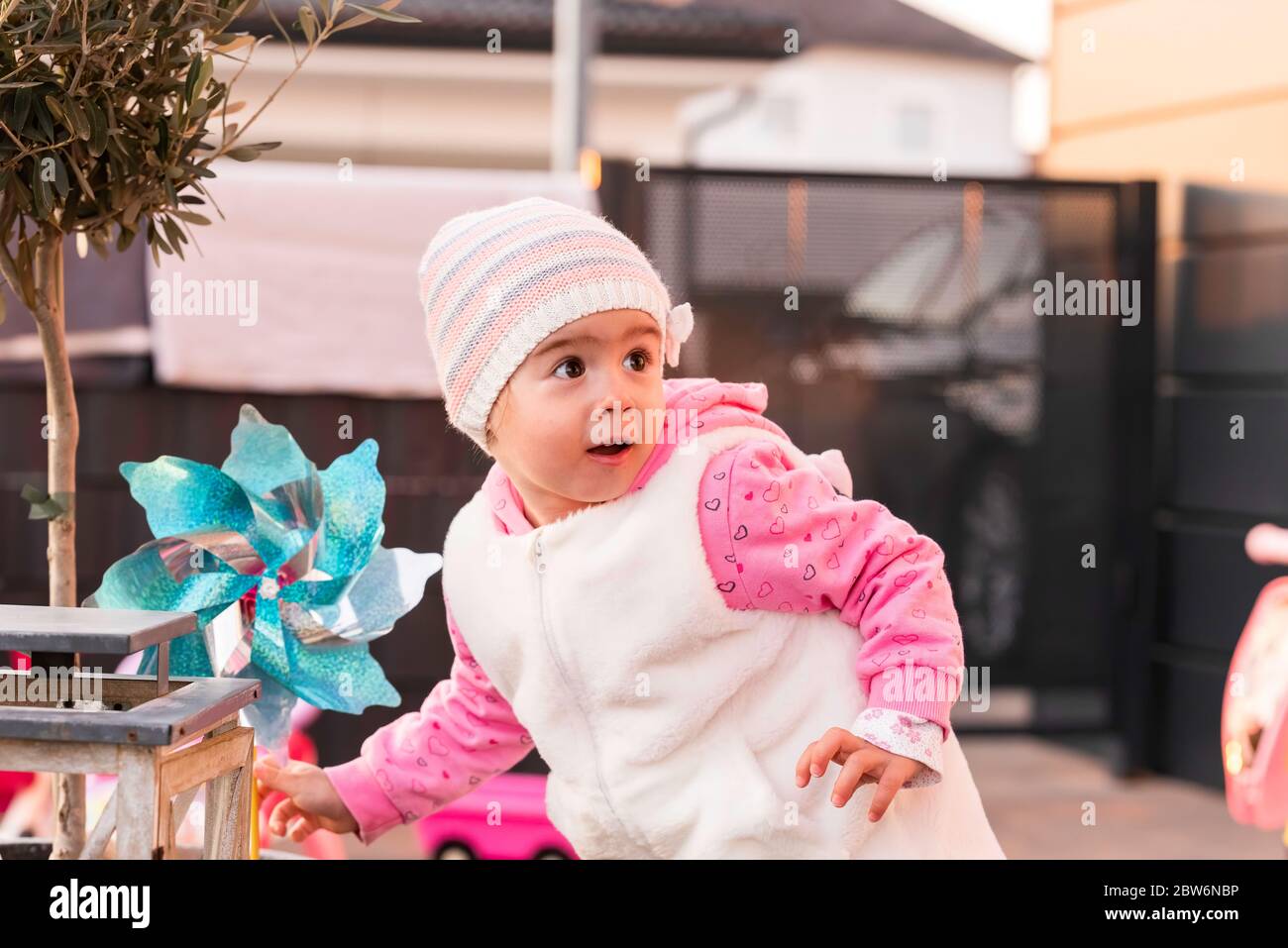 Adorable baby girl with cap in backyard portrait Stock Photo - Alamy