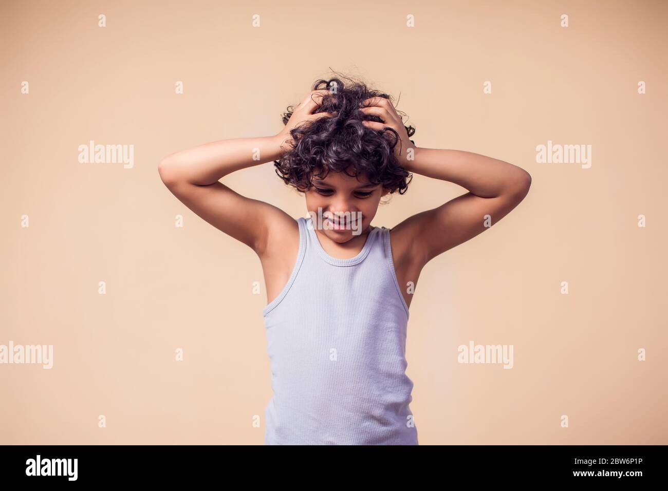 A portrait of sad kid boy with curly hair. Children and emotions ...