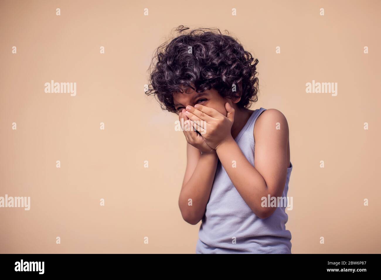A portrait of sad kid boy with curly hair. Children and emotions ...