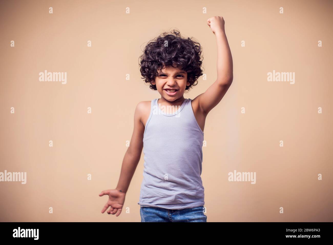 A portrait of angry kid boy with curly hair showing aggresion. Children ...