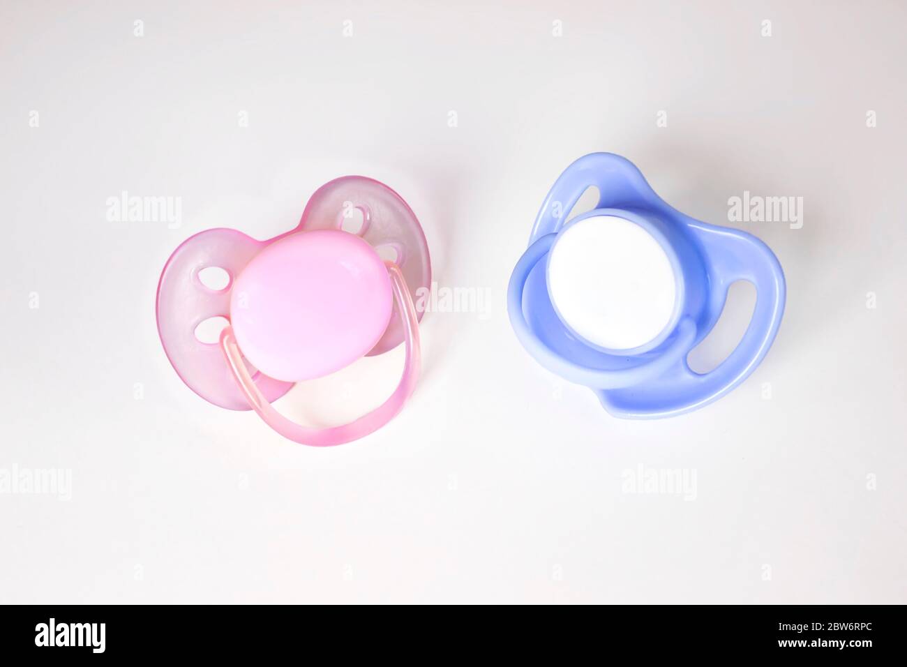 Pink and Blue Pacifiers on a white background. Two pacifiers close-up ...