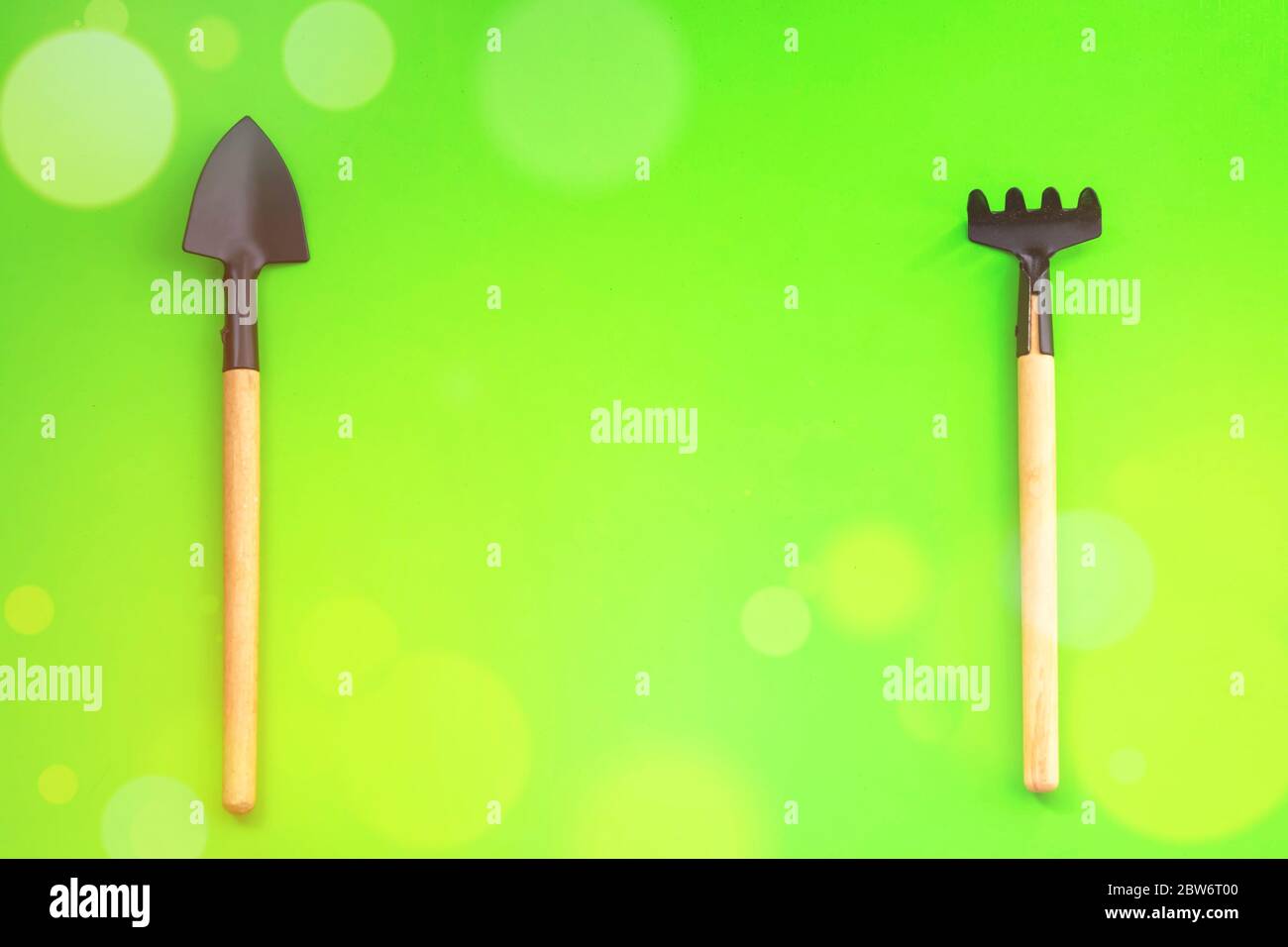 Miniature gardening tools on green background. Top view. The concept of ...