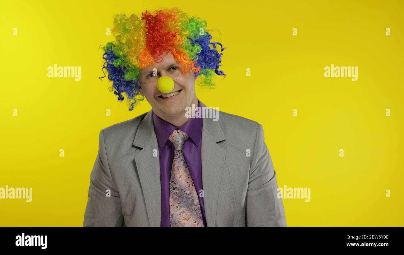 Happy clown director office worker in wig and business suit at work ...